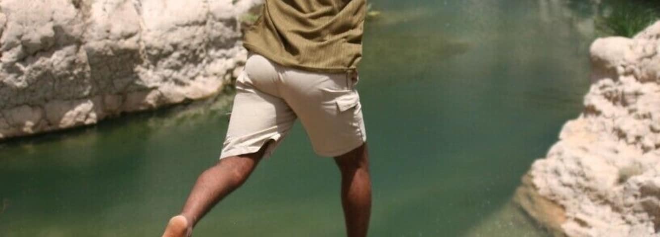 Wadi Shab is a truly magical place that is made even more amazing with a little local knowledge.  To get there from Muscat, no 4WD required.  Head along the road to Sur and not long after Fins Beach, take a turn off (slipway) to the right for Wadi Shab or Tiwi Village - it is signposted.  Head down under the road and turn left to go underneath the highway.  When you come out from under the bridge, do not turn immediately right, cross this road and turn right immediately after it.  Follow this road through the village and down the steep hill to the causeway.  When you cross over the causeway, turn right and park under the highway.
Once you have reached here, you need to take a boat across to the other bank in order to walk up the Wadi.  It costs 300 baisa (about 80 US cents).  Try to have small change for this - you would be lucky if these guys carried change for a 10, let alone anything bigger.  Check what time the last boat goes back - it changes with the season.
Once you are across, there is a long but rewarding walk ahead.  Luckily there are lots of stunning pools to take a dip in along the way.  In 2012, Red Bull held the finals of the Cliff Diving Championships here.  Eventually, the walk kind of stops at the water's edge.  There is just a rock wall in front of you and a beach of smooth rock to enter the wadi.  This is where it is time to get wet.  You will need a waterproof bag if you are carrying valuables and I strongly recommend water shoes of some kind.
Keep following the wadi upstream.  There will be some climbing over rocks and up small gravelly waterfalls and some swimming.  How much will depend on the current water level.
You will reach a rock wall in front of you and the wadi just seems to appear out of it.  There are now only 2 ways to go - back where you came from - or through the wall.  There is a crack in the middle of the wall.  Go to where this "meets" the water.  If the water level is high, it will be all the way up and the only way through is to swim under rock.  This is without a doubt dangerous going in blind and one of my least favourite things.  I won't do this.  If the water level is low enough, which it always has been for me, you can "swim" under, with enough room to get your head through, so you can both see and breathe - a much safer option.  You can use your hands on the rock to propel you through.
What do you do all of this for...?  You are now in a cave with a waterfall.  It is partially open at the top, so it is shady rather than dark and the locals have fixed a rope up through the waterfall so you can climb up and jump in.  With so many other options further down river for jumping in or stopping in the shade by the water, this may seem like a lot, but it is truly beautiful.
Note:  Take plenty of drinking water, sunscreen, hat and energy food.  It is warm even in winter - especially if you are from colder climes.
But most of all - enjoy!  And don't be surprised if there are some local lads around eager to show you the way!