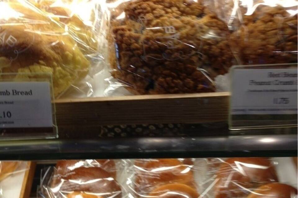 Exposição de pães numa padaria, com diferentes tipos, incluindo um letreiro indicando o preço de $1,10 para um item específico.
