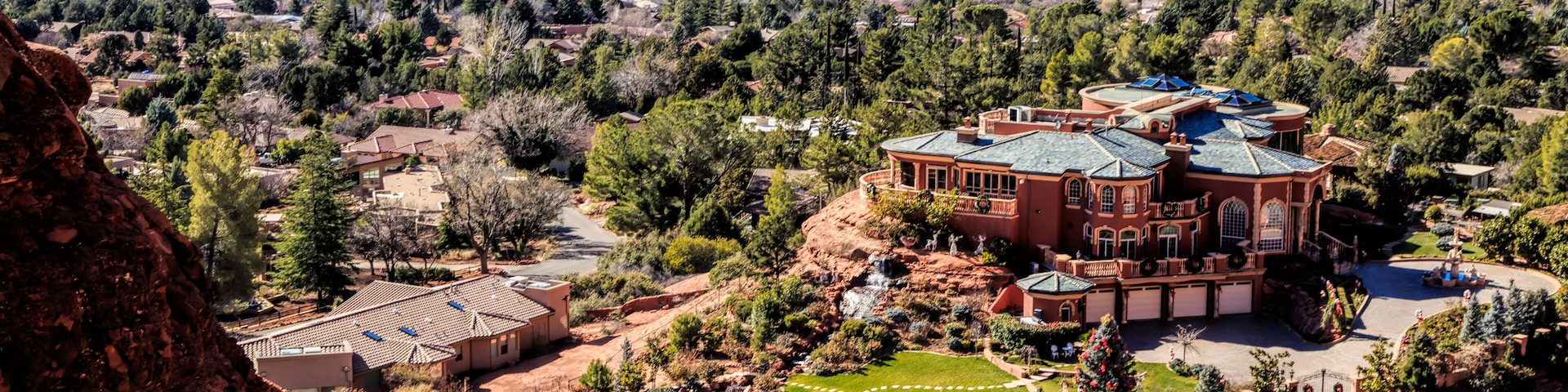 Uma grande propriedade com piscina, cercada por árvores e um cenário montanhoso.