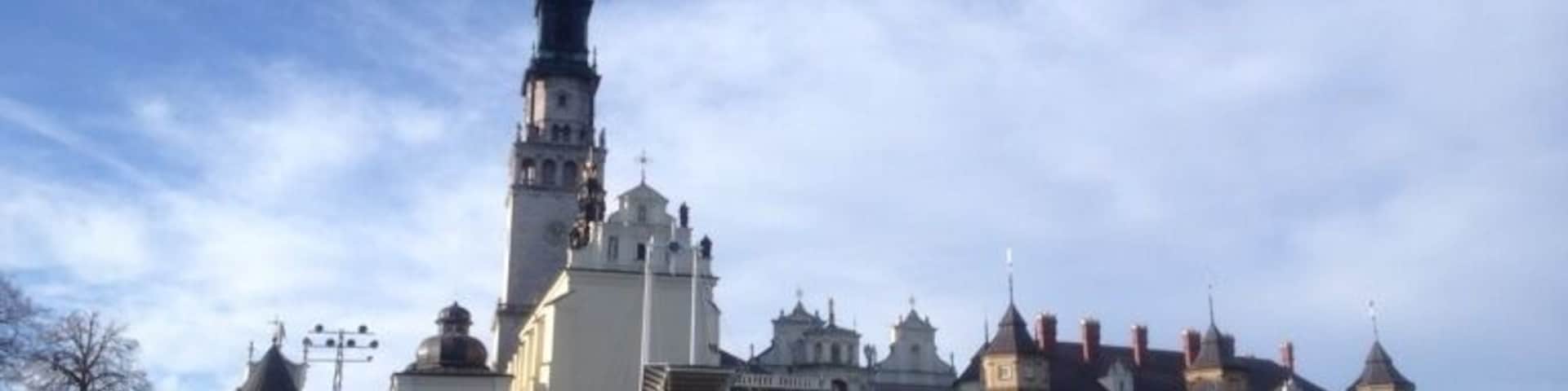 Um edifício histórico com uma torre imponente e um pátio amplo.