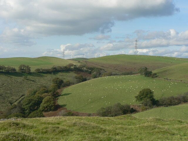Valley between Mynedd Meiros and Mynedd Portref Wind turbines can be seen on the ridge above the pastures of the valley.