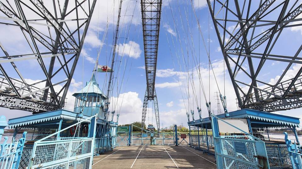 The coolest "bridge" I have ever "driven" across! Drive aboard and take flight over the River Usk in this 110 year old engineering marvel. Only six of these historic bridges remain in operation, and the Newport Bridge is the longest with a 196m span (645ft).
A modern highway bridge passes nearby, so these days the bridge operates as a novelty. Show up on either side, and the operator will come pick you up! You can also climb the steps and walk across the 54m (180ft) high catwalk.