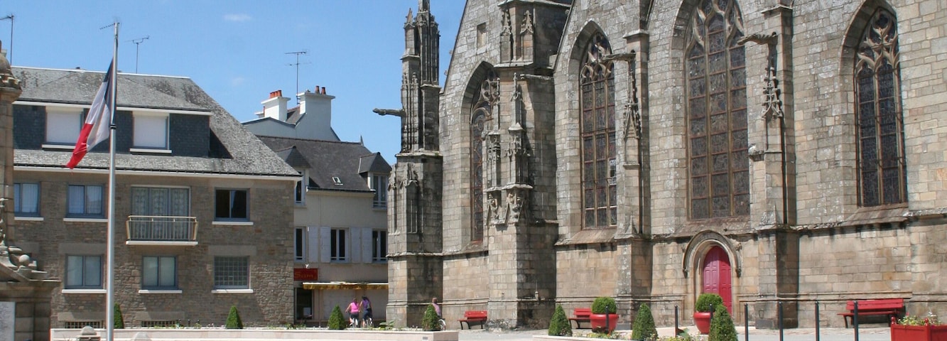 Uma igreja histórica com uma torre imponente e janelas em arco.