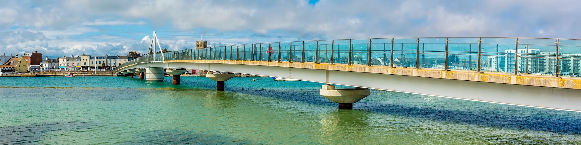 Uma ponte moderna sobre a água, com céu limpo.