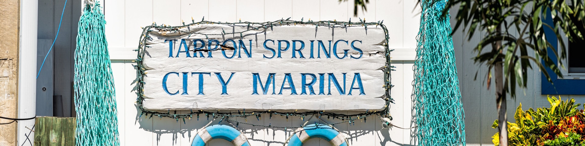 Placa da Marina Municipal de Tarpon Springs com dois boias e redes decorativas.