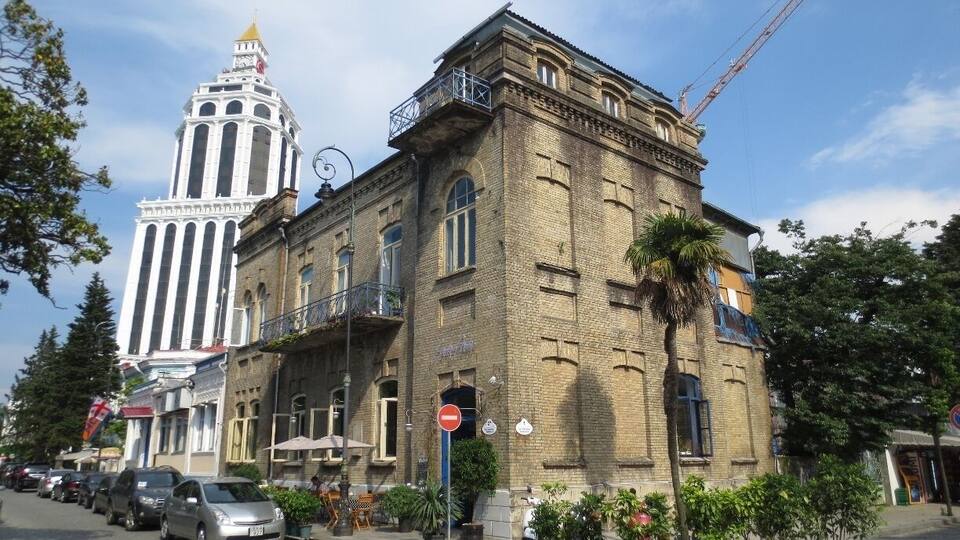 Old and new - view an old brick building in the Black Sea coastal city of Batumi, Georgia.
Construction crane and modern tower in the background.