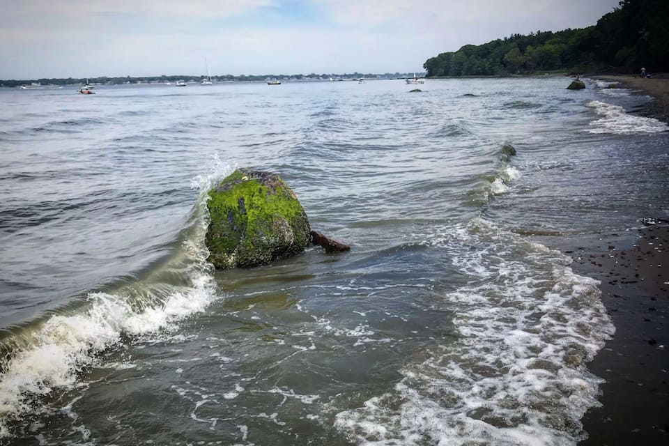 Uma costa rochosa com ondas quebrando na praia.