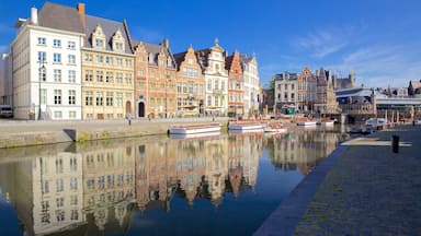 Um canal com barcos, edifícios históricos e um céu azul límpido.