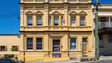 A yellow building with "Regional Council Chambers" on the facade.