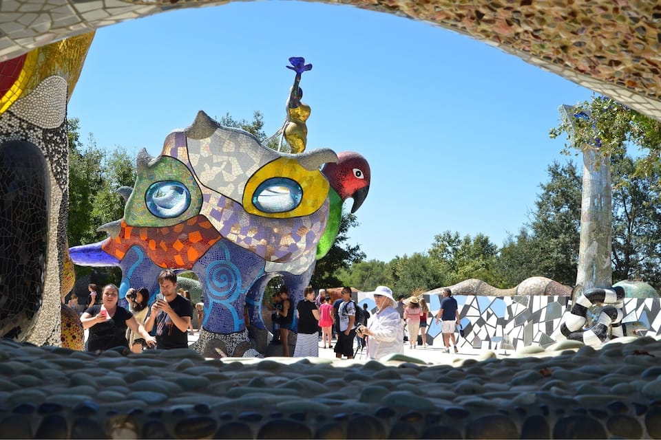 Escultura de mosaico colorido com um papagaio e uma tartaruga.