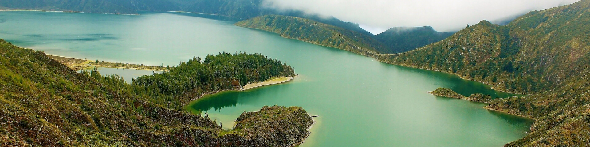 I took this in March in the Azores Islands, Portugal! It's at Lagoa do Fogo, a crater lake within the Água de Pau Massif stratovolcano. This is one of the most iconic spots on São Miguel Island! And the highest lake on the island, too. And I was there on a beautiful misty day :). In fact, I liked it so much there I visited it twice! It's incredible to be high up, but also down at the lake too which I was :). There is so much pristine beauty here. As in most of this island!