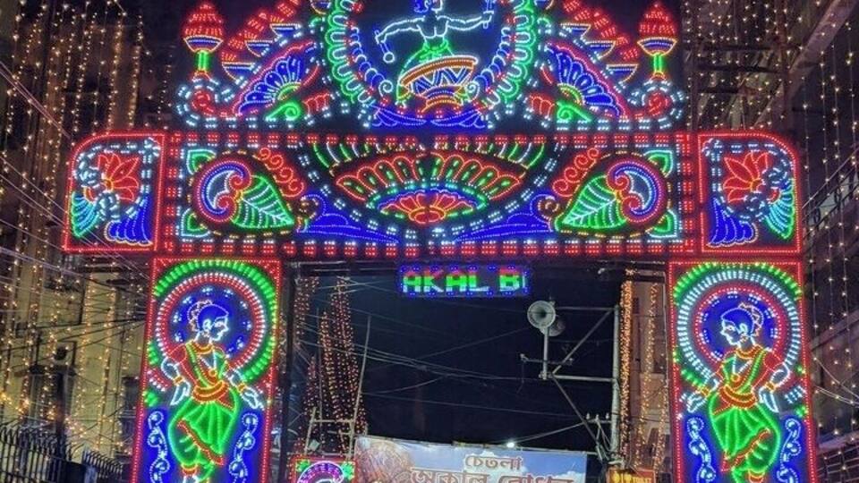 Uma passagem iluminada com luzes e padrões coloridos, cercada por uma multidão de pessoas.