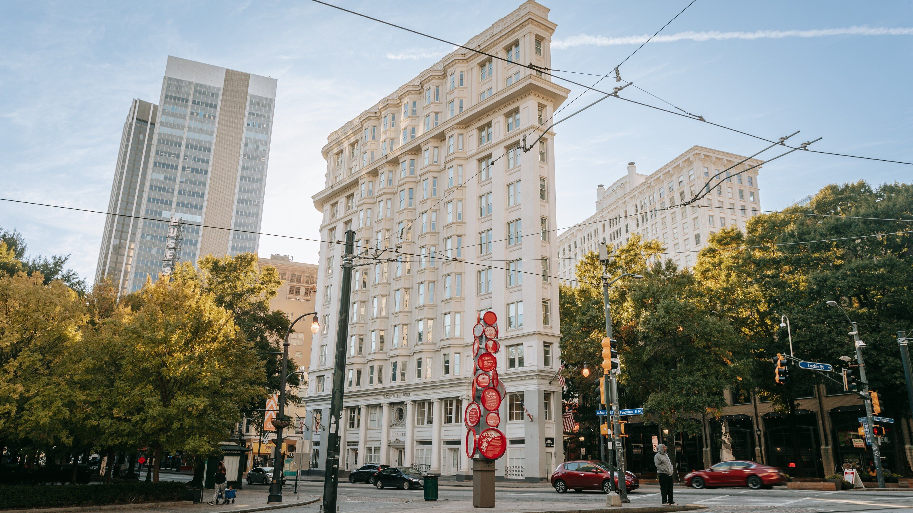 Rua urbana com edifícios históricos, um arranha-céu moderno e uma placa de rua indicando Locke St.