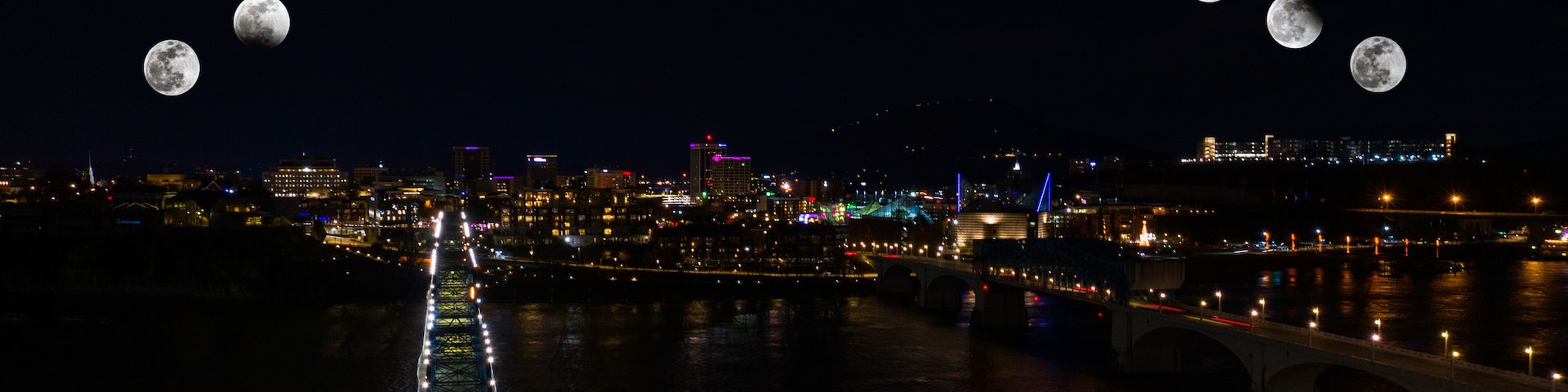 Paisagem urbana com rio, ponte e uma série de luas iluminadas no céu.