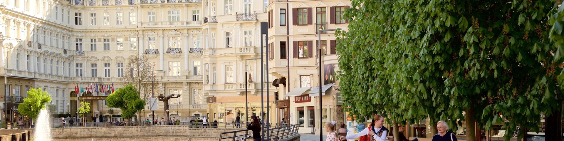 Um edifício histórico com a placa "Grandhotel Pupp", com uma fonte em primeiro plano.