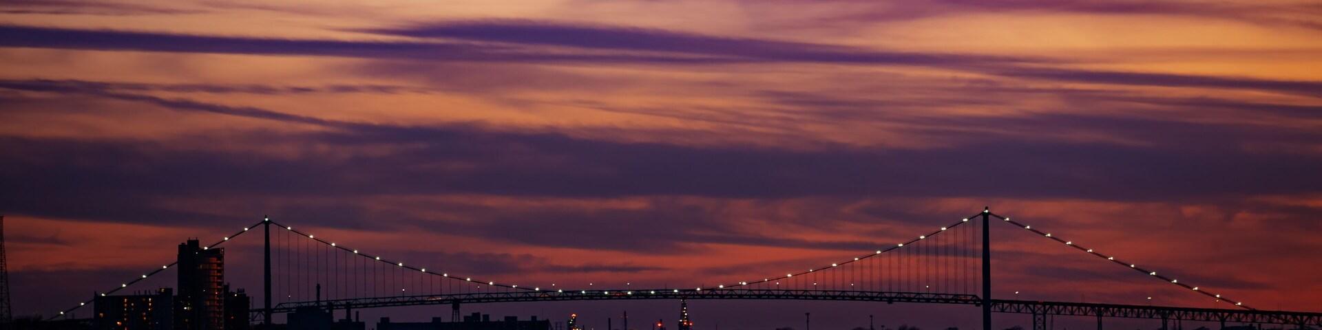 Uma ponte ao entardecer sob um céu roxo.