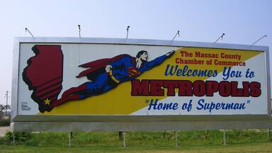 Um outdoor com Superman e o texto "Bem-vindos a METROPOLIS, lar do Superman".