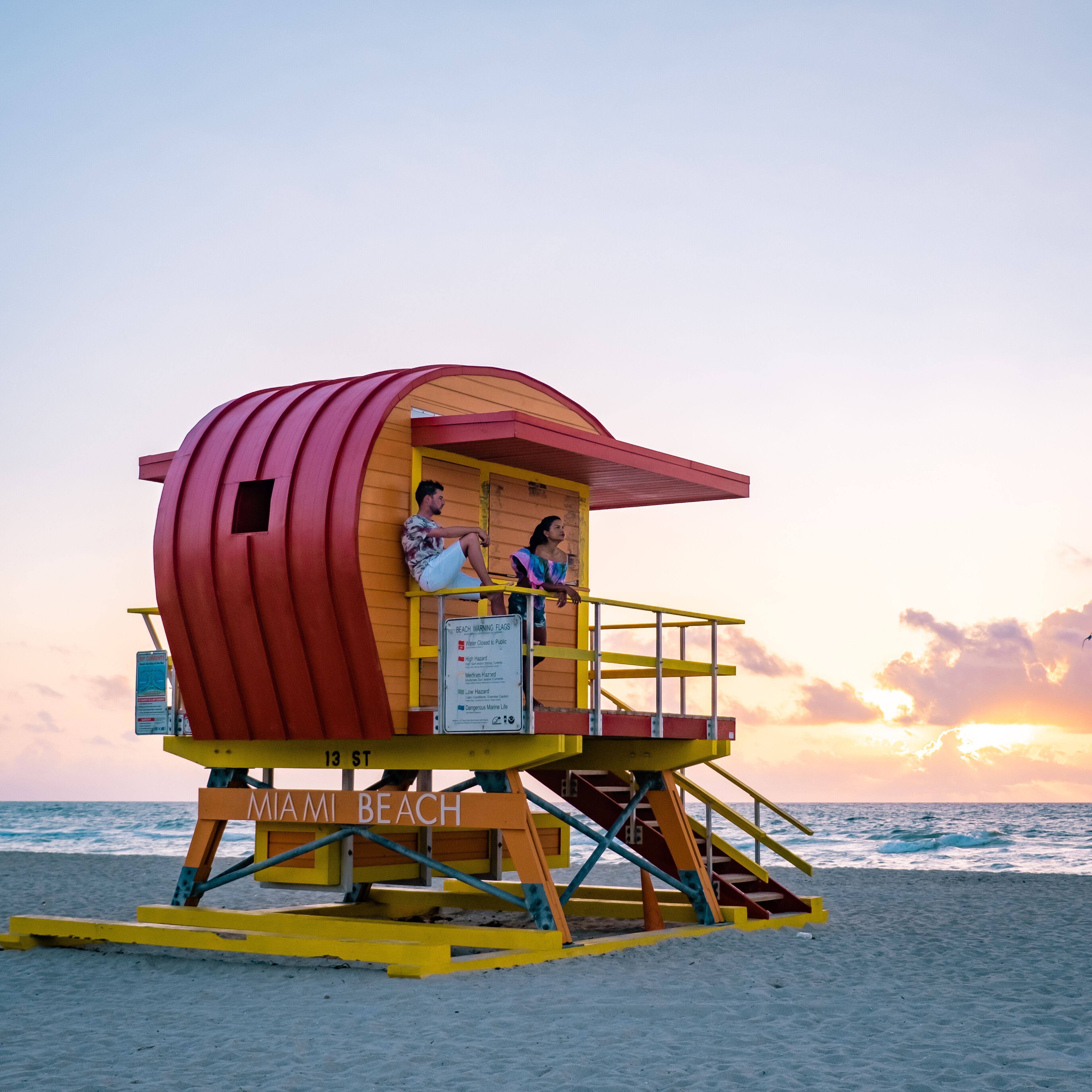 Uma torre salva-vidas na Praia de Miami sob um céu claro e ao pôr do sol.