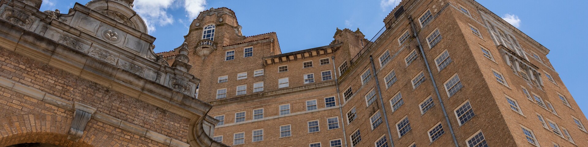 Um edifício histórico com arcadas e uma torre.