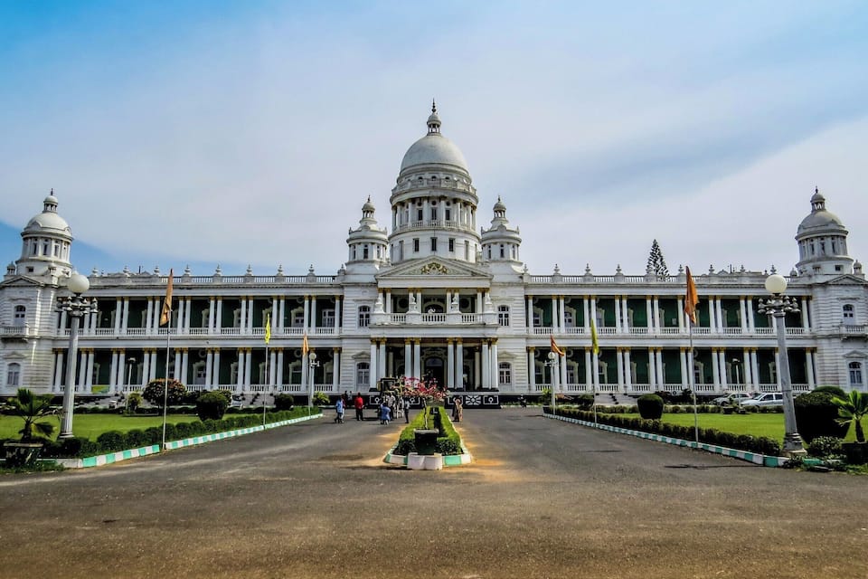 Um imponente edifício colonial branco, com uma cúpula central e alas simétricas.