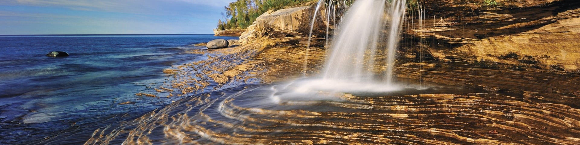 Munising showing a waterfall and rugged coastline
