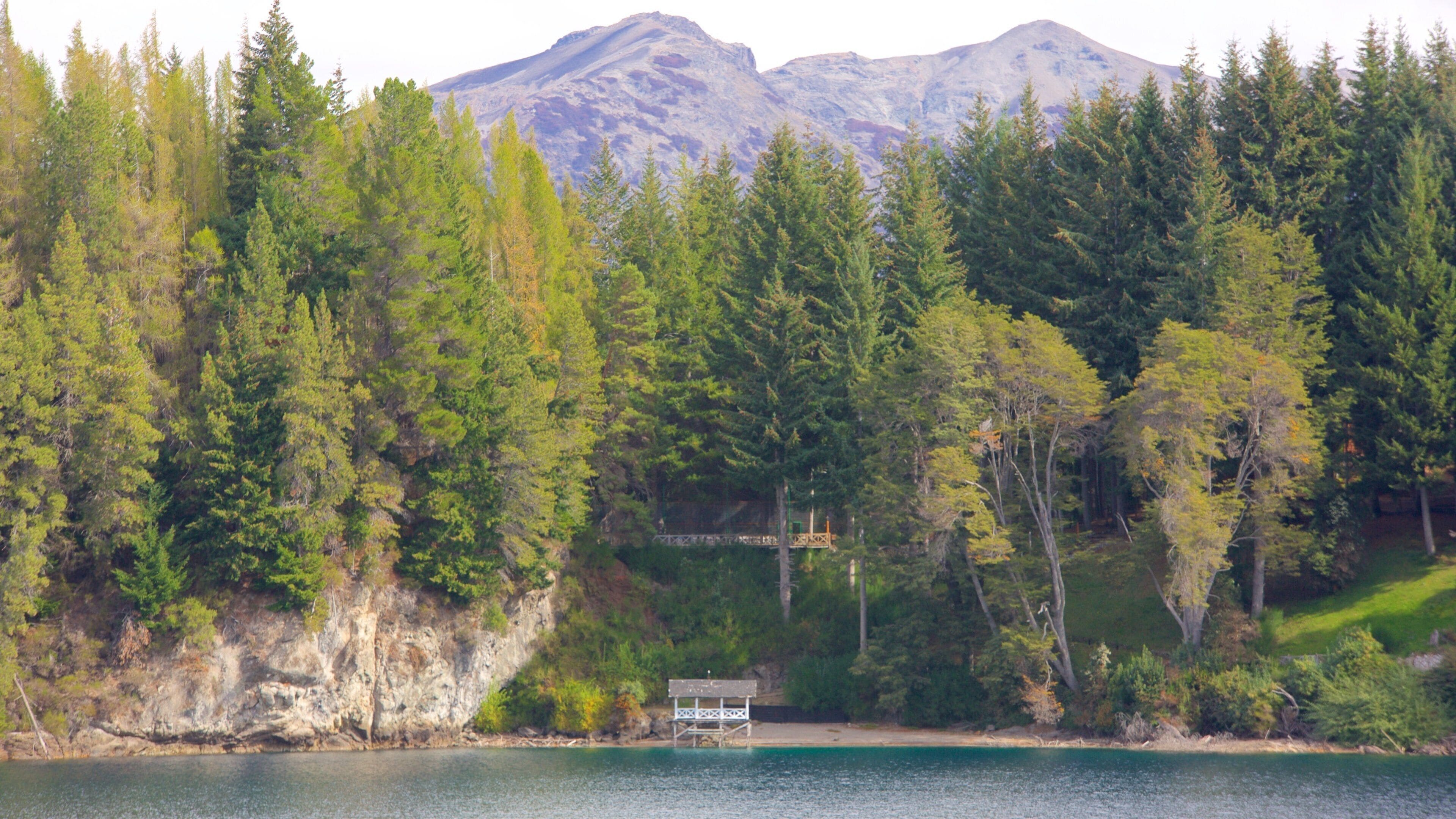 Um lago rodeado por floresta densa e montanhas.