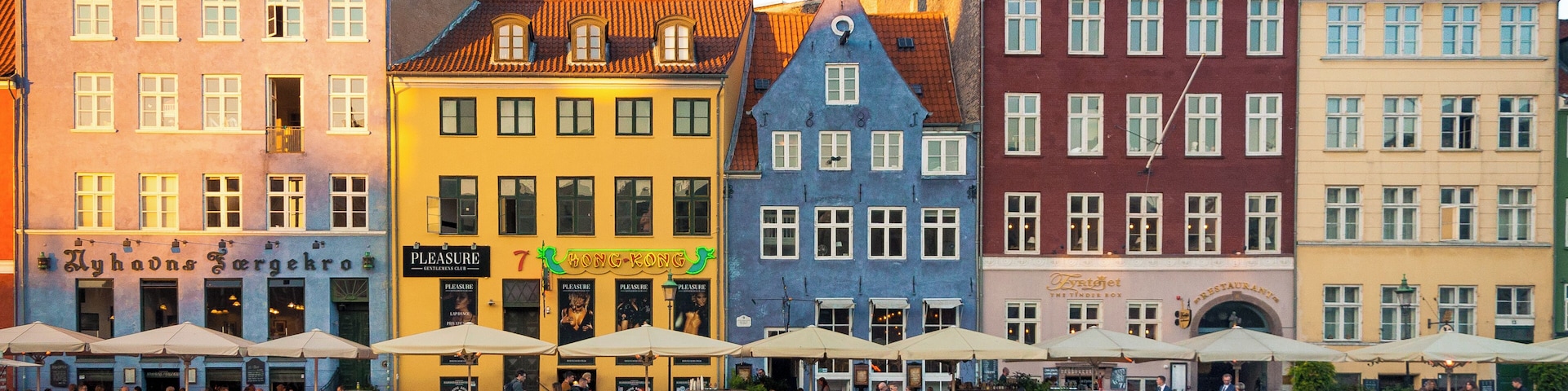 Nyhavn (New Harbour) is a 17th-century waterfront, canal and entertainment district in Copenhagen, Denmark. Stretching from Kongens Nytorv to the harbour front just south of the Royal Playhouse, it is lined by brightly coloured 17th and early 18th century townhouses and bars, cafes and restaurants. The canal harbours many historical wooden ships.