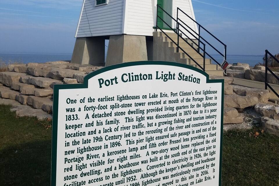 Um farol com uma porta verde e um laço vermelho no topo.