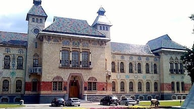 Um edifício grande e ornamentado, com várias torres e uma entrada central.