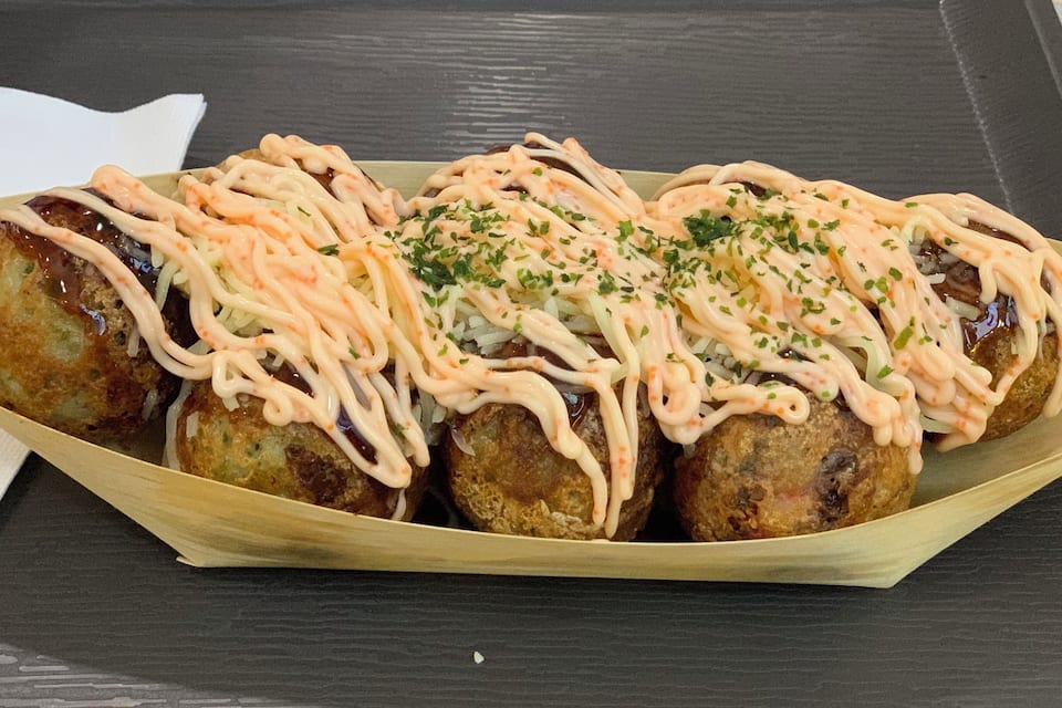 Uma travessa de comida com almôndegas cobertas de molho e guarnecidas com ervas.