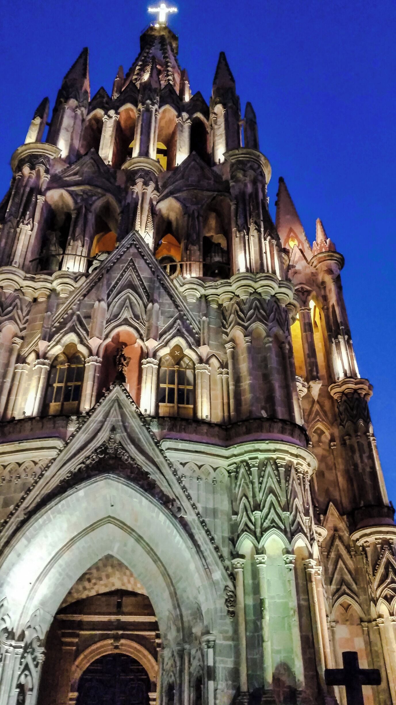 Uma catedral gótica com uma torre imponente e janelas iluminadas.